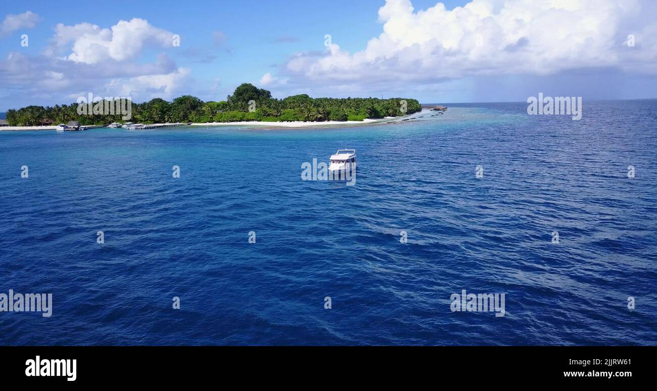 A beautiful view of a boat in a calm sea with an island on a summer ...