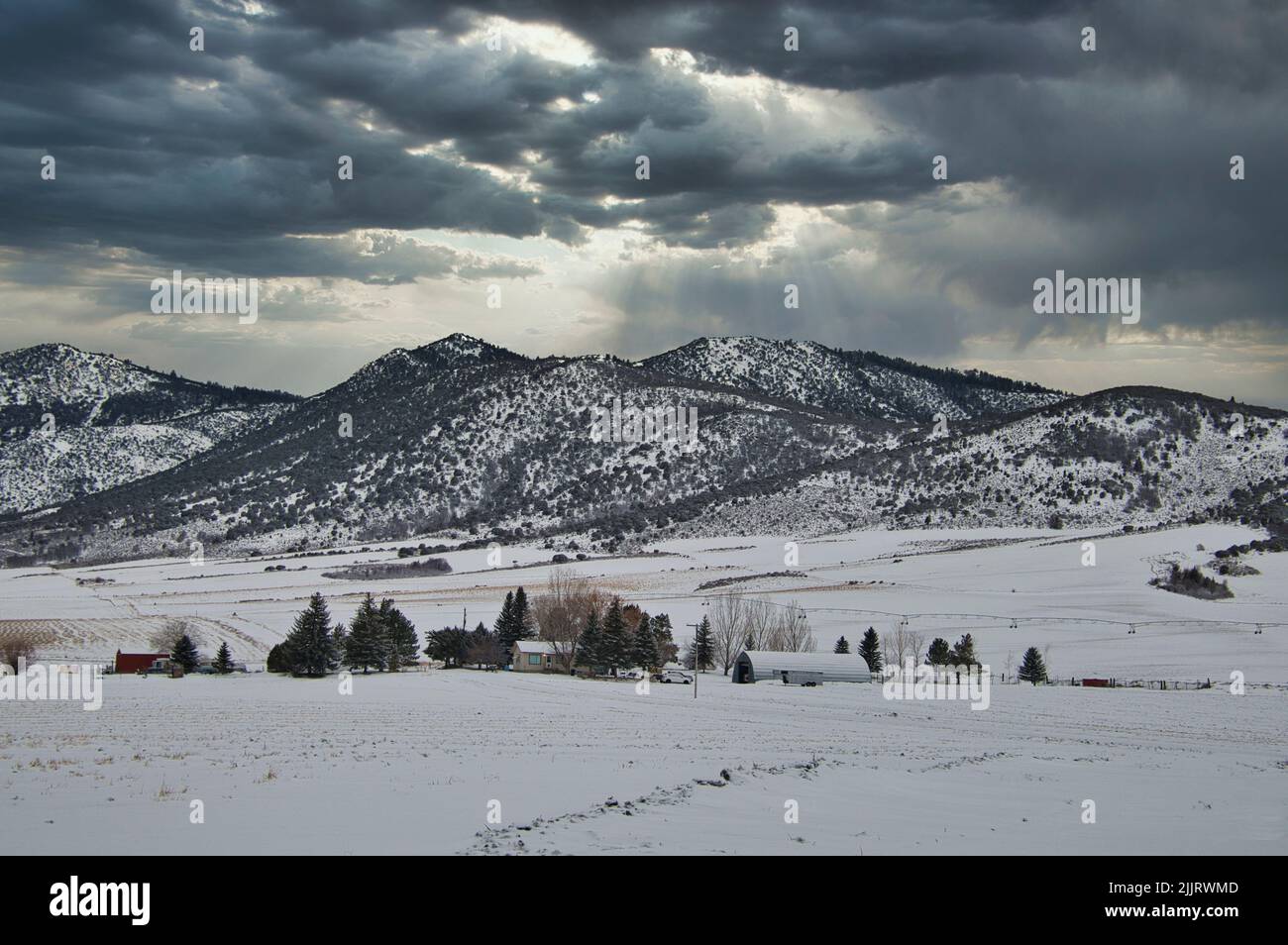 A scenic view of mountains and a valley covered with heavy snow under a ...