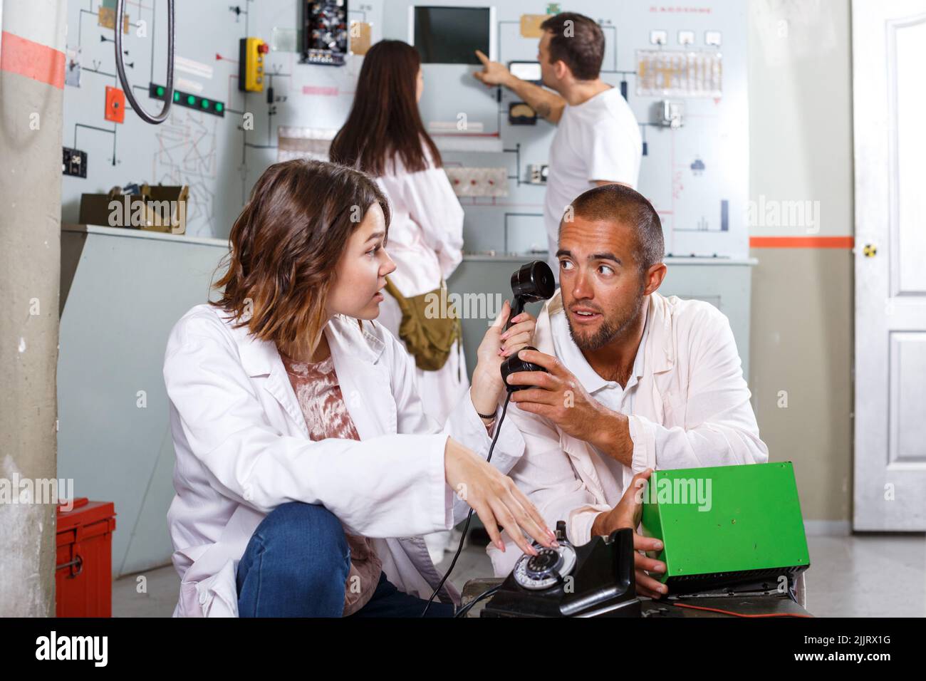 Young friends inspecting old telephone in quest room Stock Photo - Alamy