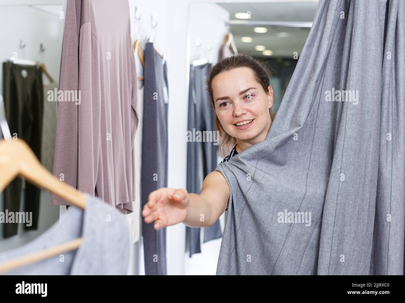 Woman trying clothes in fitting room Stock Photo - Alamy