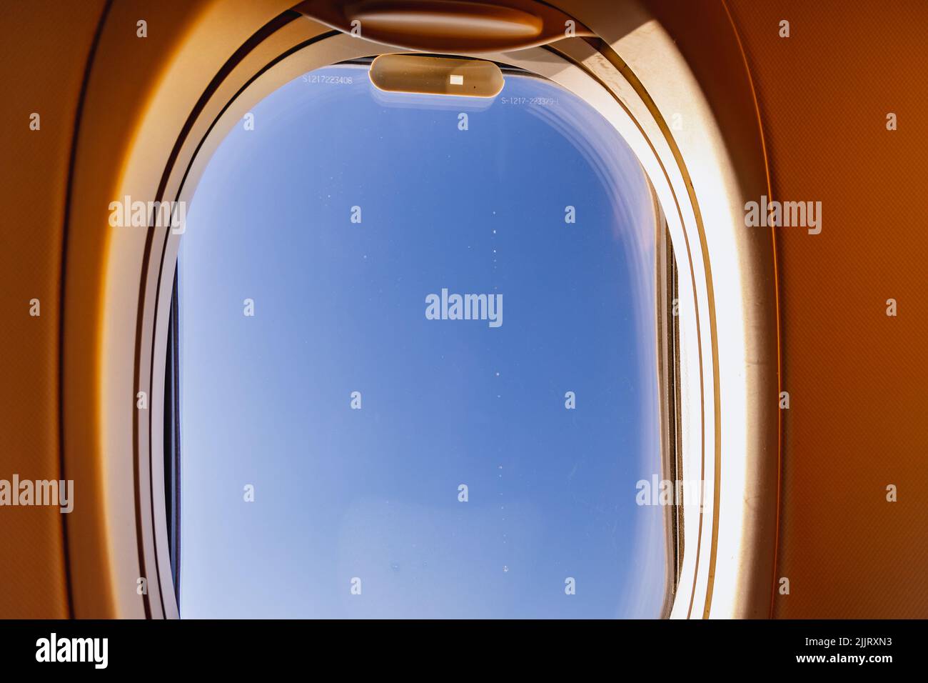 Plane window view with blue sky Stock Photo - Alamy
