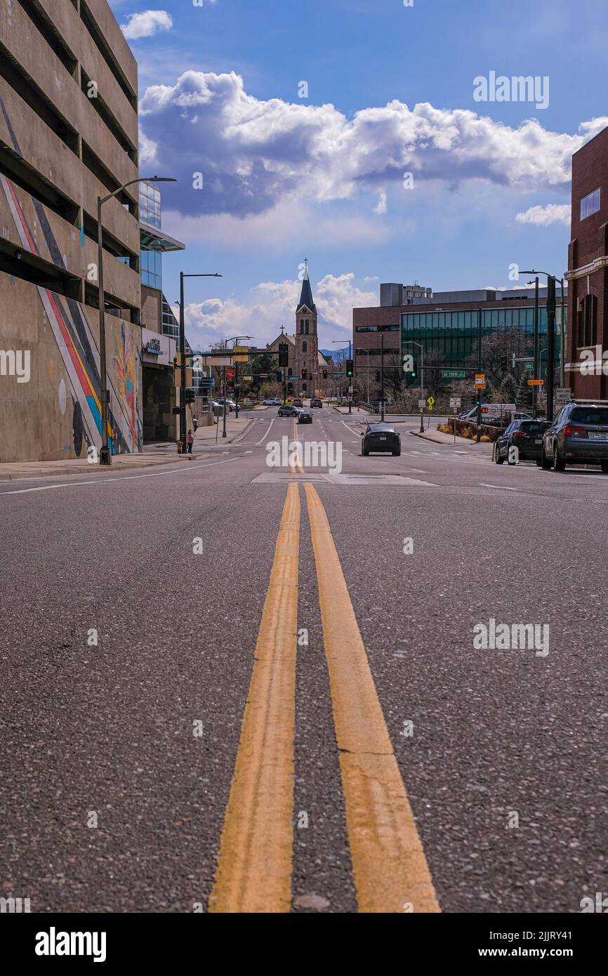 A low angle shot of an asphalt street with cars driveway to a church in ...