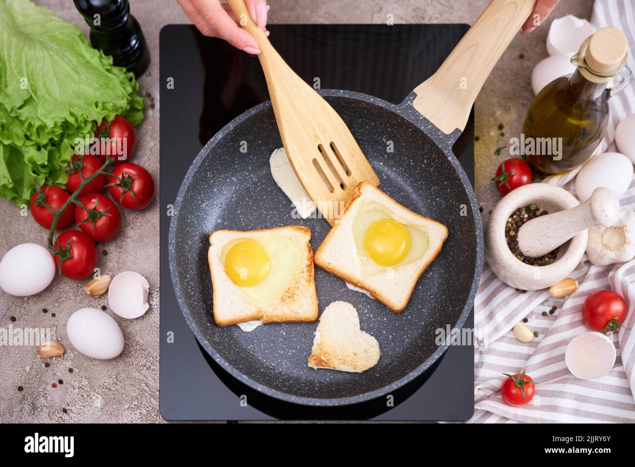 Fried egg Toasts with heart shaped holes on frying pan Stock Photo - Alamy