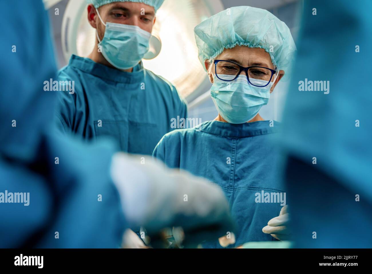 Team Of Surgeons In The Operating Room Preparing For Surgery Stock