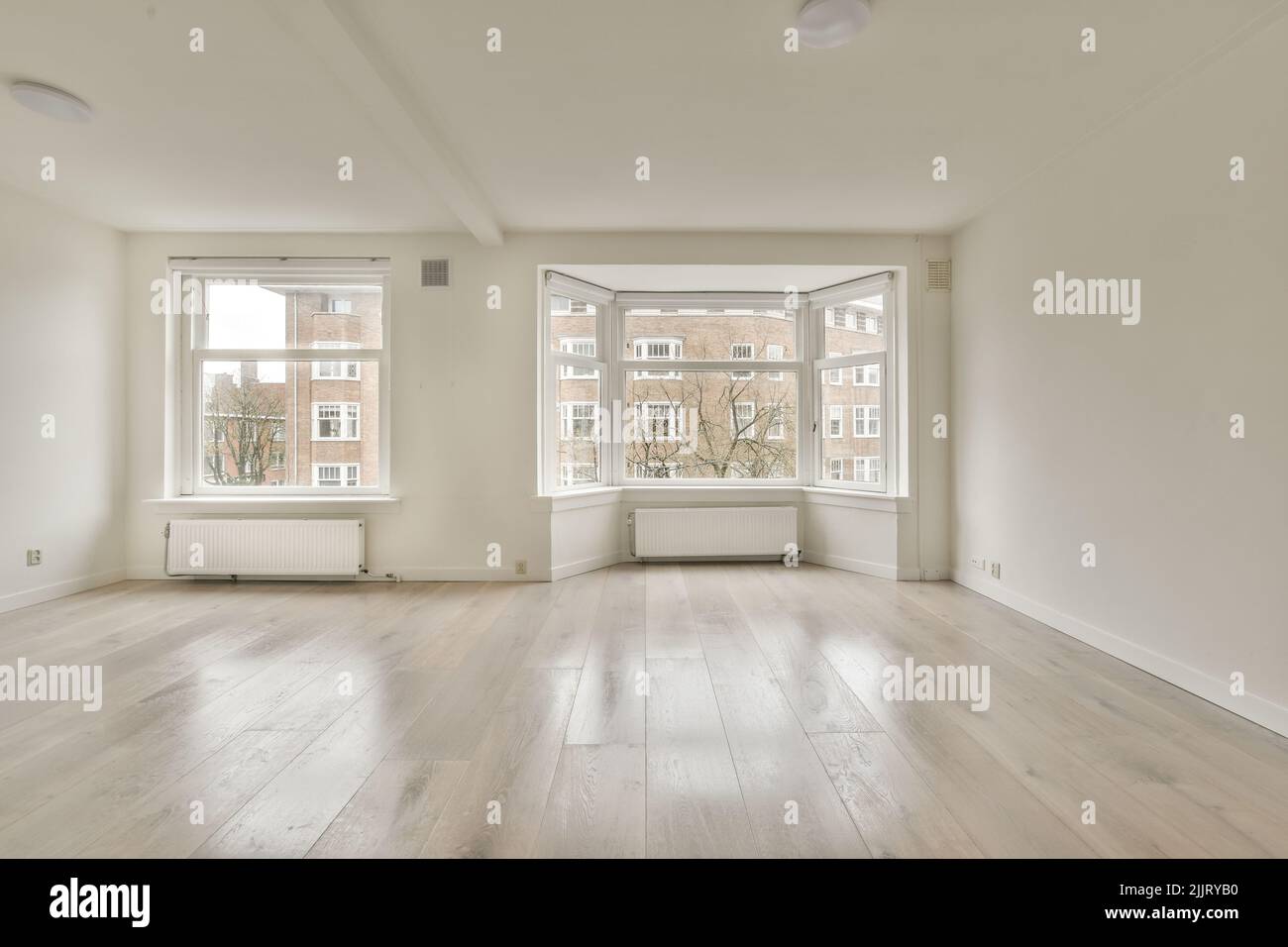 Plastic window and radiator on white wall in empty light room at home ...