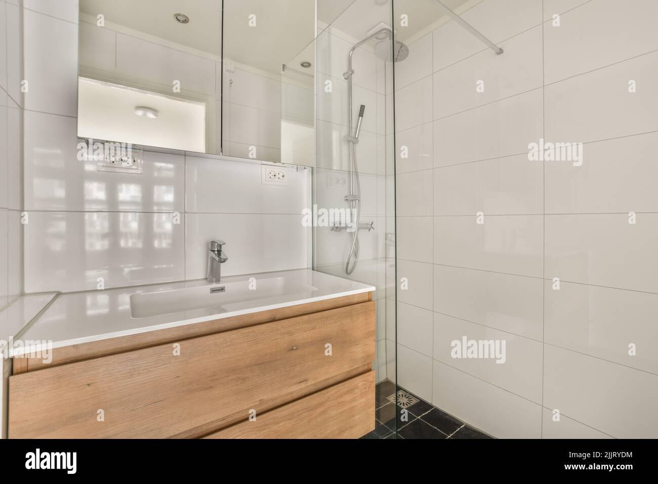 Sinks with mirrors and shower box with glass door in modern bathroom ...