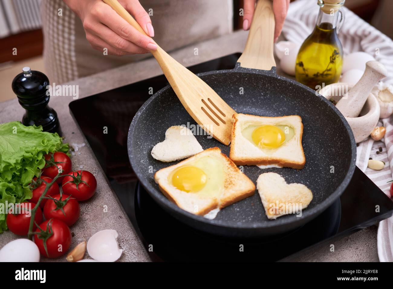 Fried egg Toasts with heart shaped holes on frying pan Stock Photo - Alamy