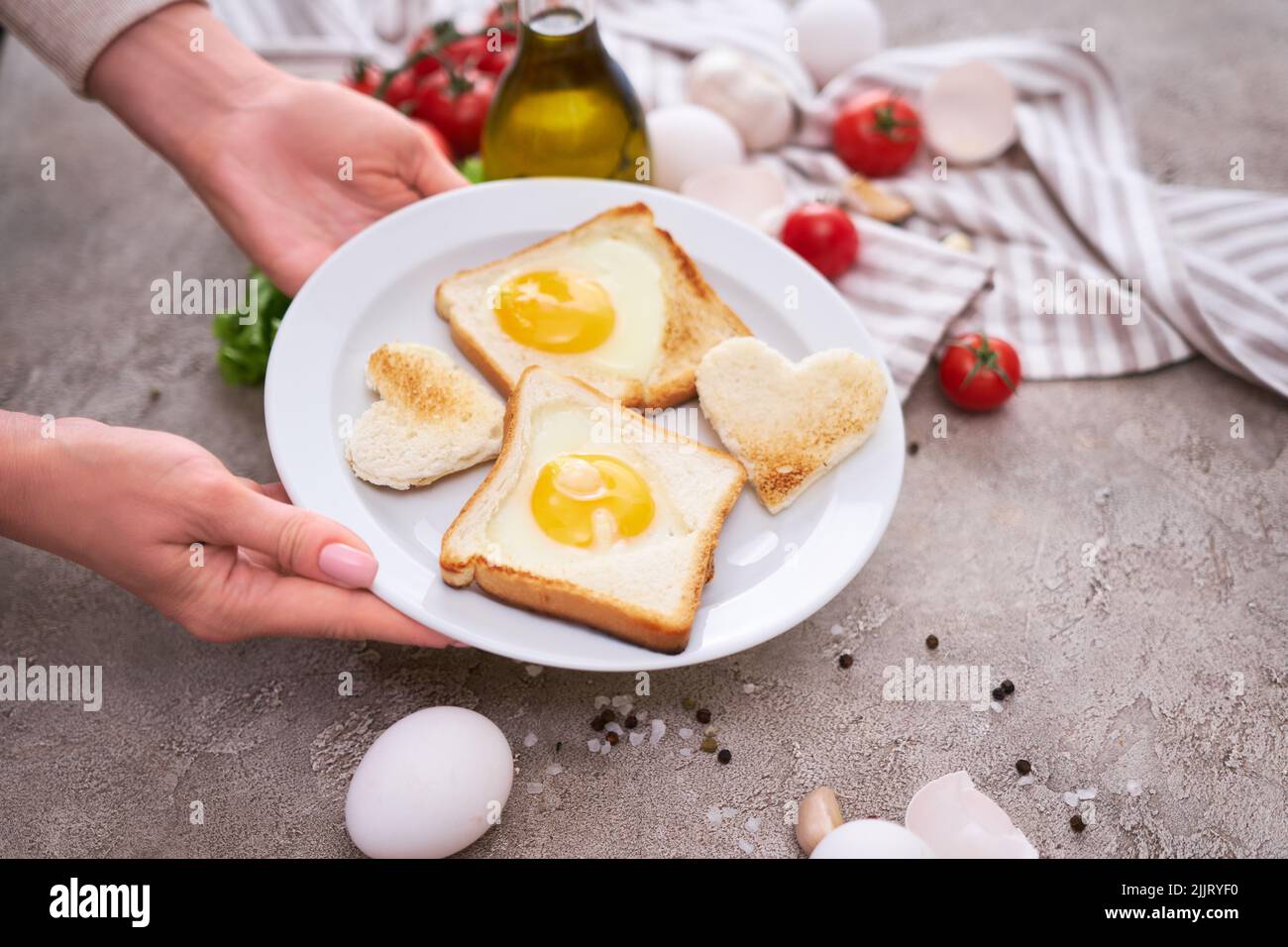 Woman pits plate with Fried Egg on Toast Bread on concrete table for ...
