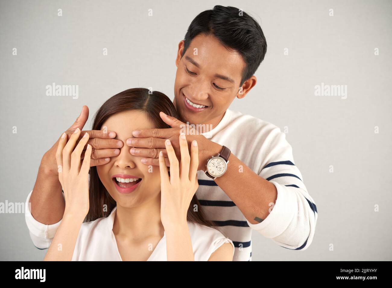 Making Pleasant Surprise To Girlfriend Handsome Asian Man Standing