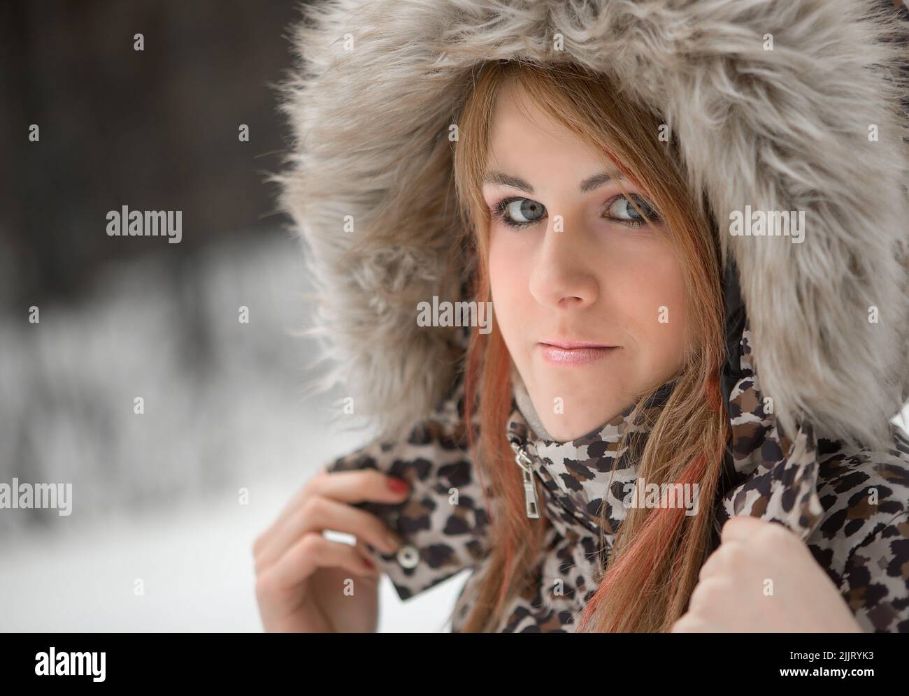 A Portrait of a caucasian young woman wearing a winter leopard print ...