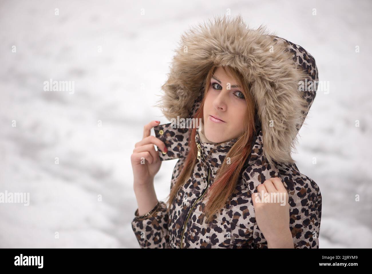A Portrait of a caucasian young woman wearing a winter leopard print ...