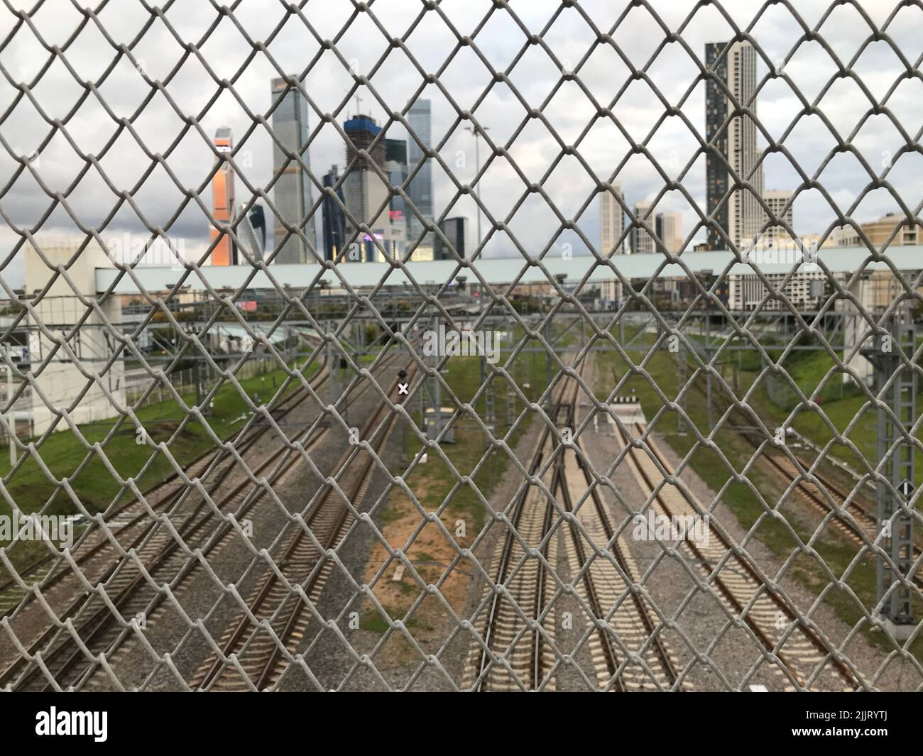 The Moscow City skyscrapers view through a grid taken from a bridge ...