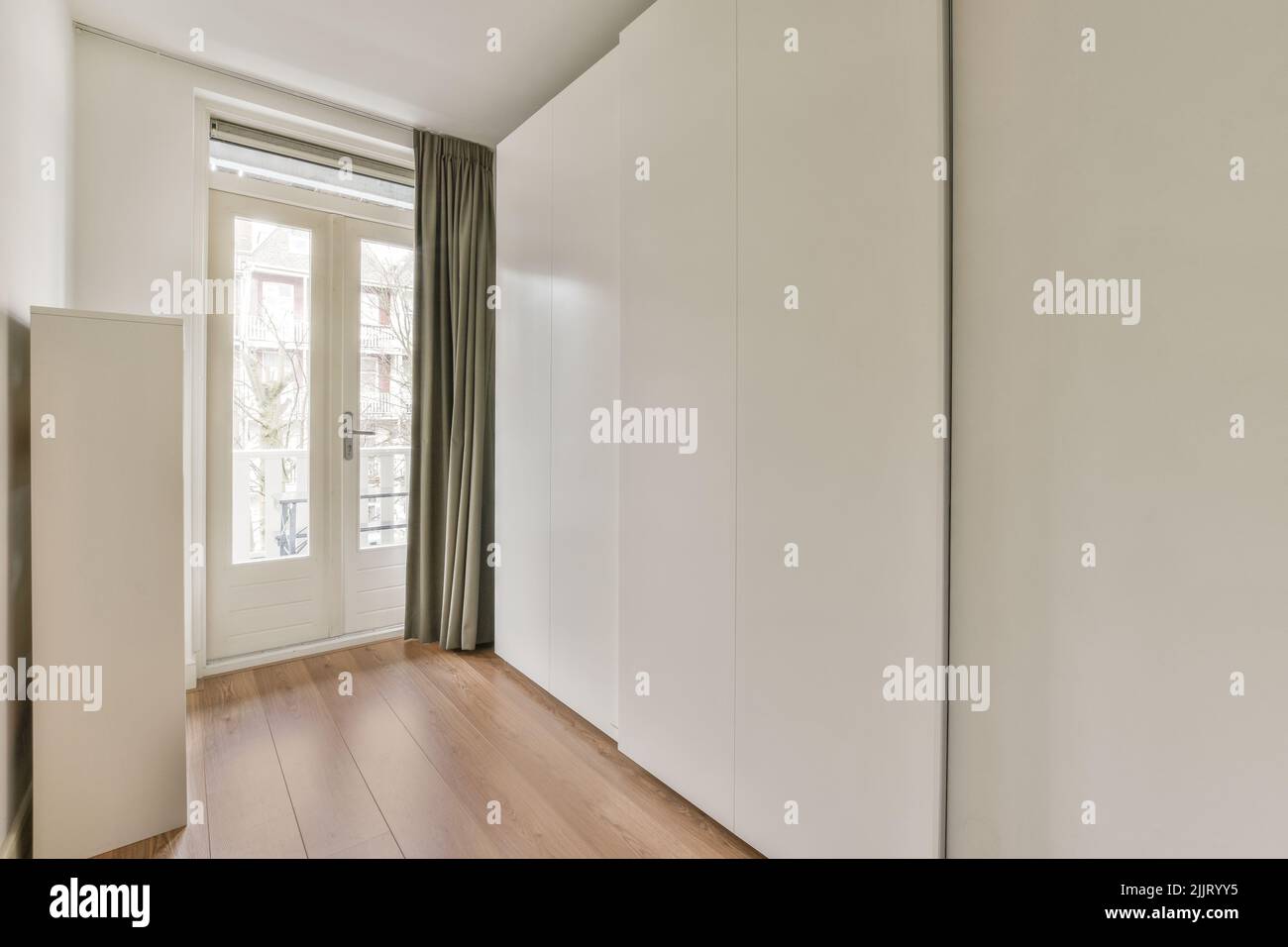 Modern cupboard and vintage chest placed near doors and wicker basket ...