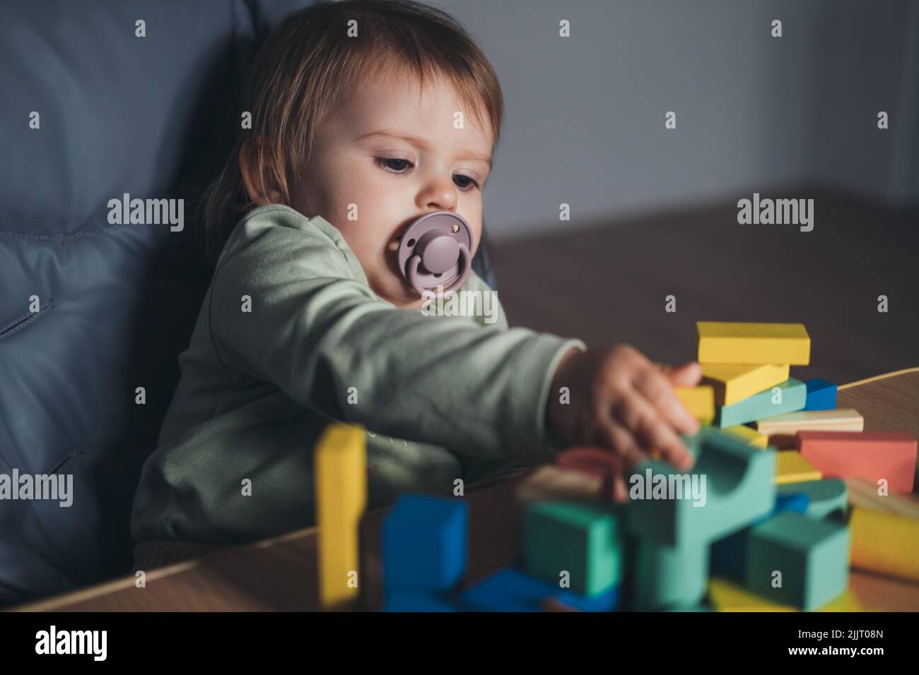 Baby girl playing with wooden blocks toy building a tower. Concept of ...