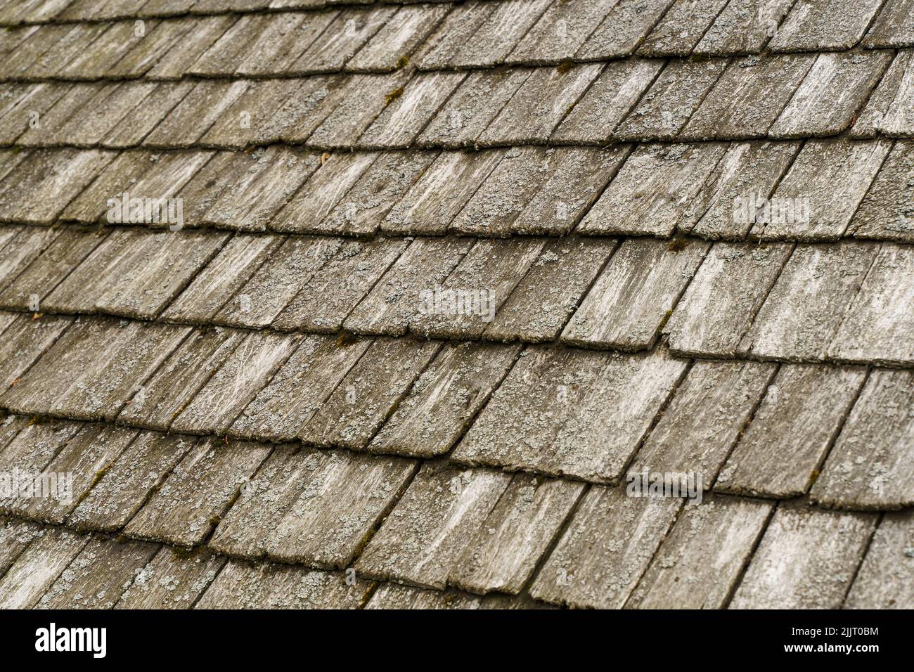 Old wooden roof tiles on the roof of a village house background. High ...