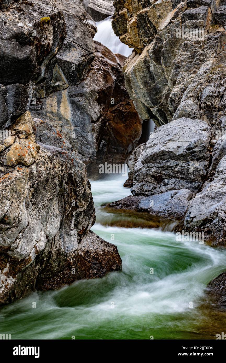 A vertical shot of a river between high rocky cliffs Stock Photo - Alamy