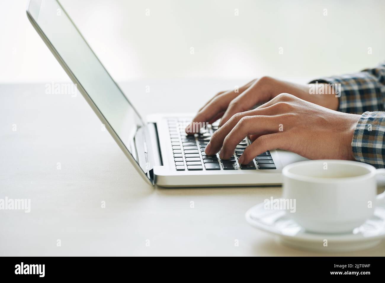 Cropped image of person programming on laptop and drinking coffee Stock ...