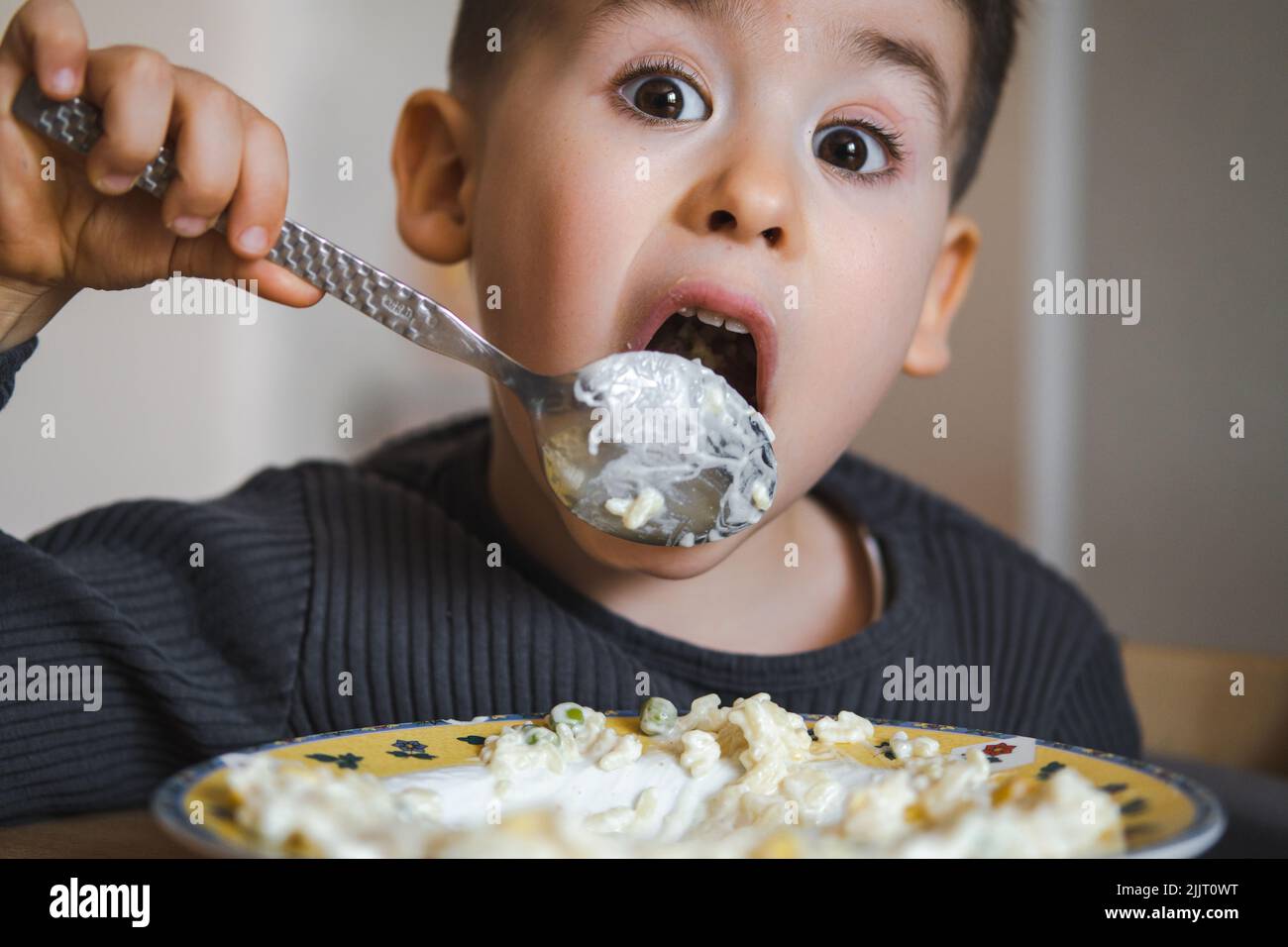 Kid eating pasta with sous, dining at table in kitchen. Healthy ...