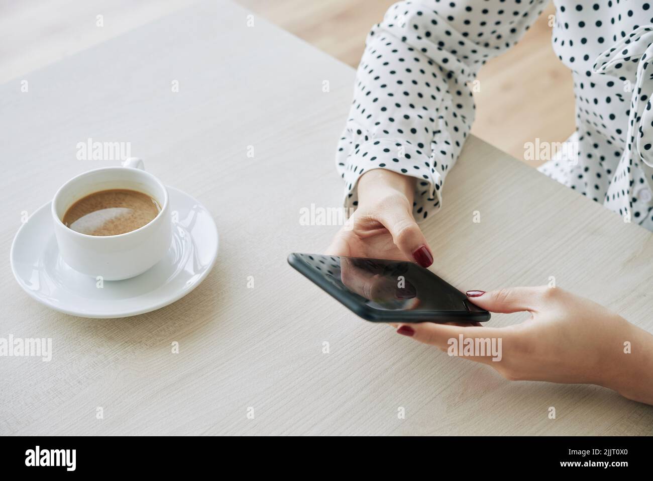 Drinking coffee checking smartphone messages hi-res stock photography ...