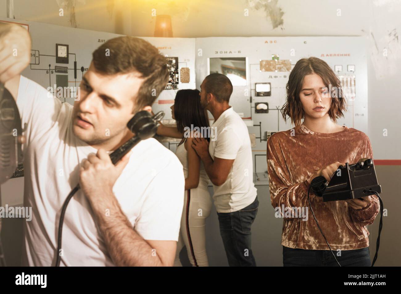 Young people with old telephone in lost room-bunker Stock Photo - Alamy