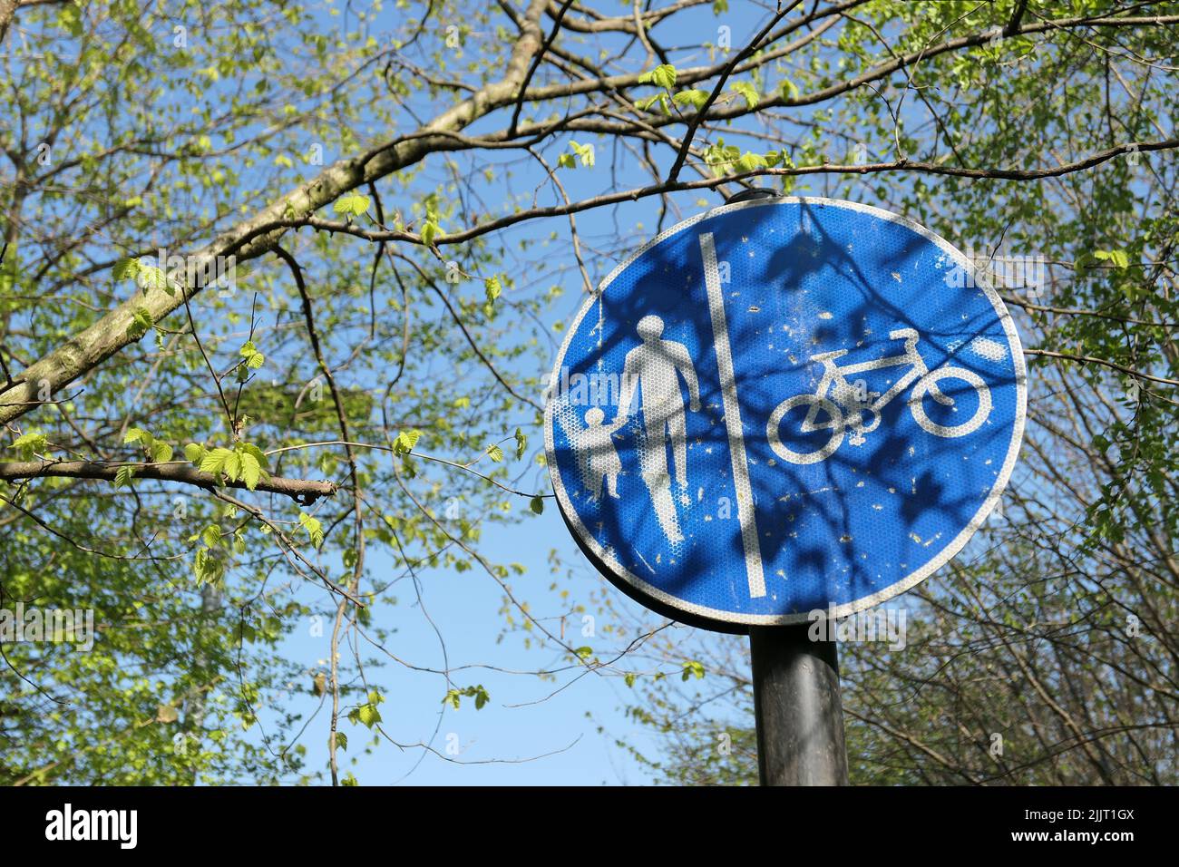 A blue circular road sign allowing the passage of pedestrians and ...