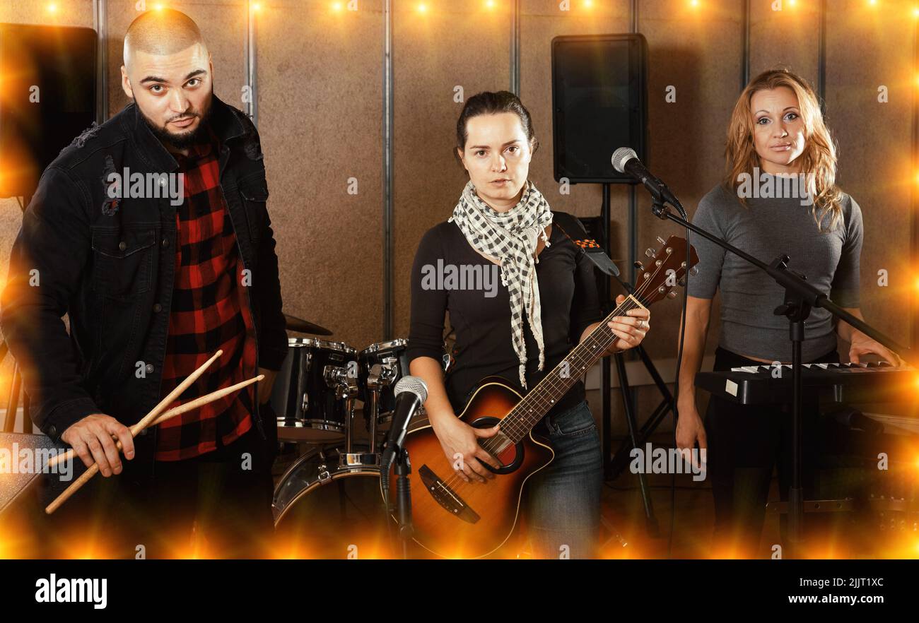 expressive group of rock musicians posing with instruments Stock Photo ...