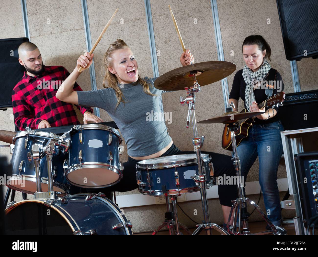 Music band with jolly girl drummer rehearsing Stock Photo - Alamy