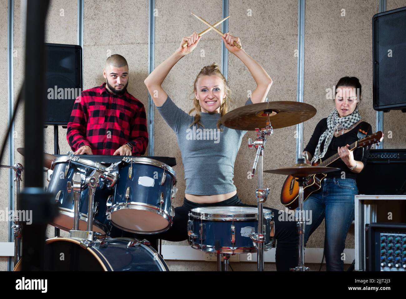 Music band with glad girl drummer rehearsing Stock Photo - Alamy