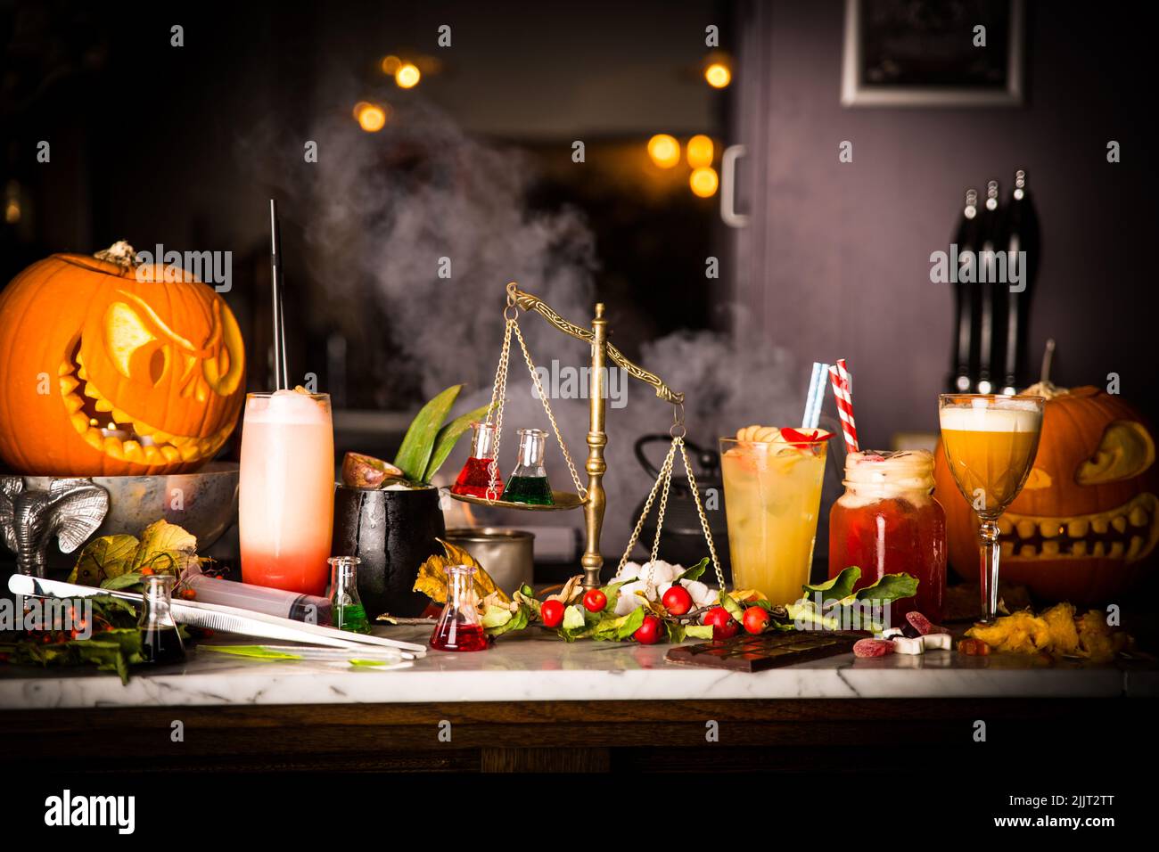 A table full of glass of different cocktails decorated with pumpkins ...