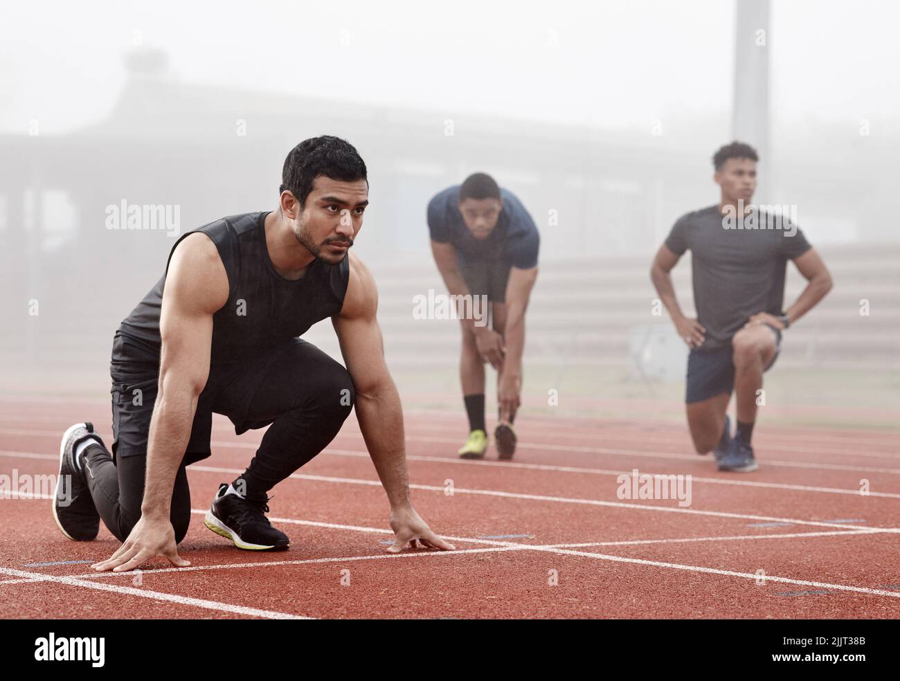 Ready to leave you all in the dust. a male athlete ready to begin a ...