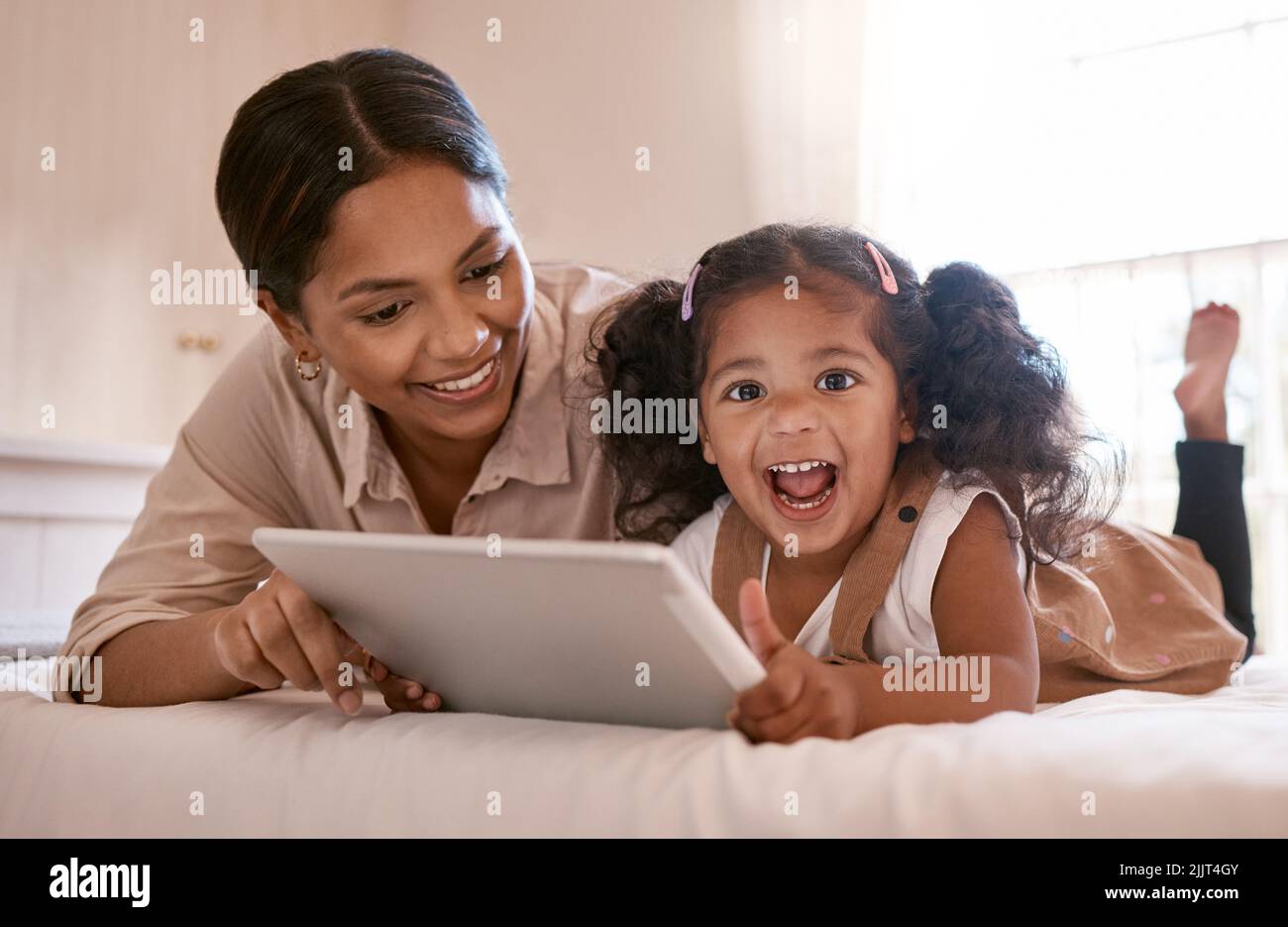 A mother and daughter bond is forever. a little girl using a digital ...