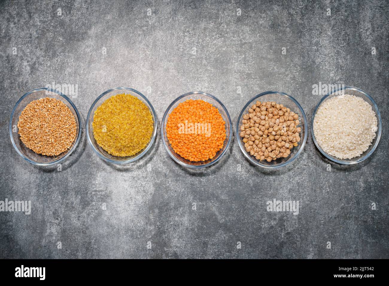 A top view of various legumes with spelt, bulgur and pearl barley in ...