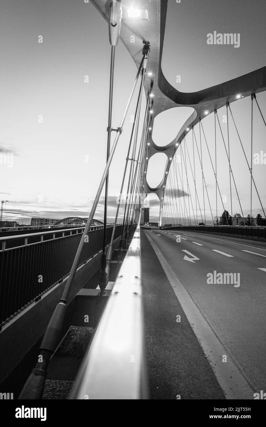A vertical grayscale shot of a modern bridge with newly built asphalt ...
