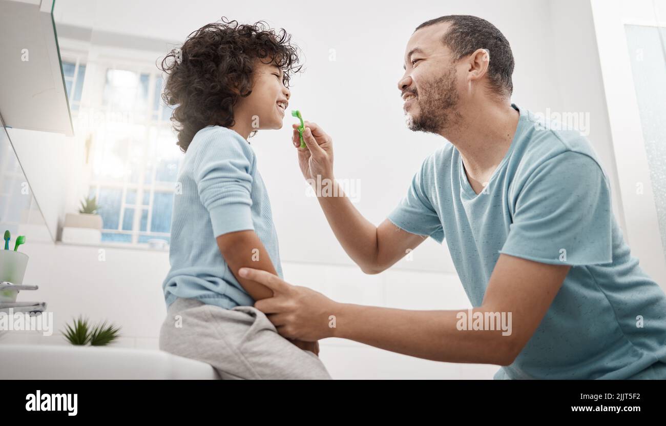 Your little teeth are so precious. a father brushing his little sons ...