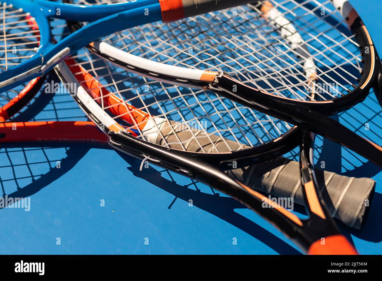 broken tennis rackets blue tennis court Stock Photo - Alamy