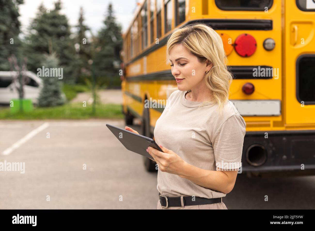 Teacher of elementary school near the school bus Stock Photo - Alamy