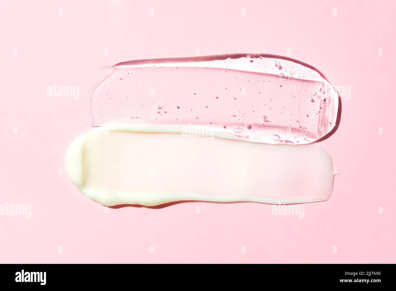 White cream and transparent gel texture on a pink background. Skin care ...