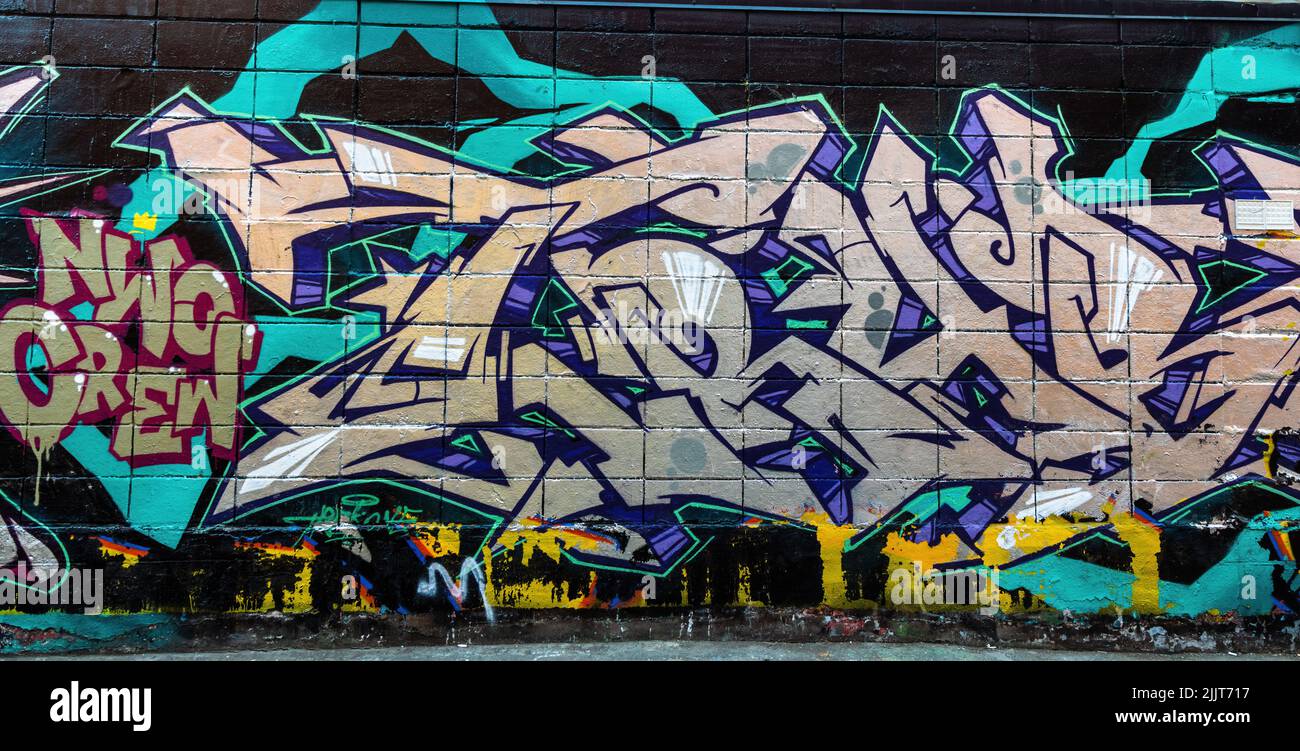 A shot of dark graffiti street art mural on a black wall in ...