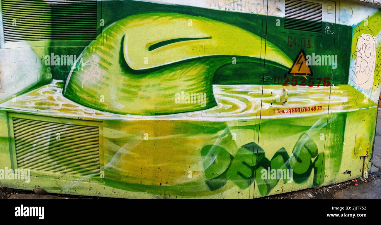 A shot of a social graffiti street art painting of neon green creature ...