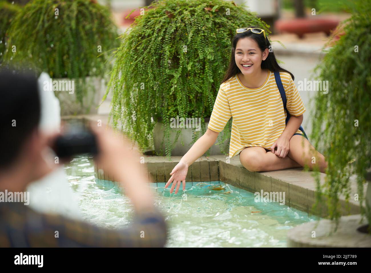 Young man photographing his girlfriend by the pool Stock Photo - Alamy