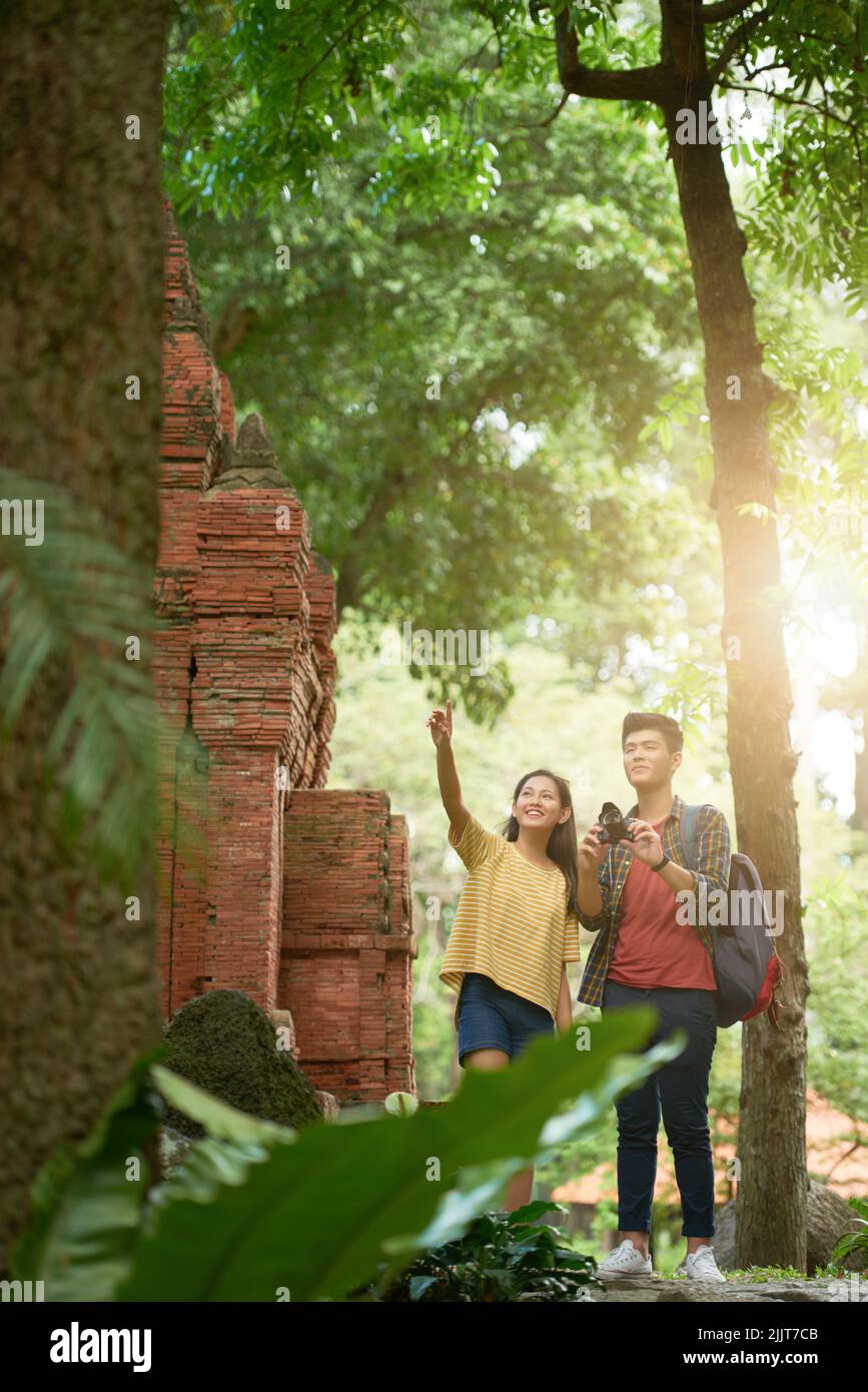 Curious tourists with digital camera walking through jungle ruins Stock ...