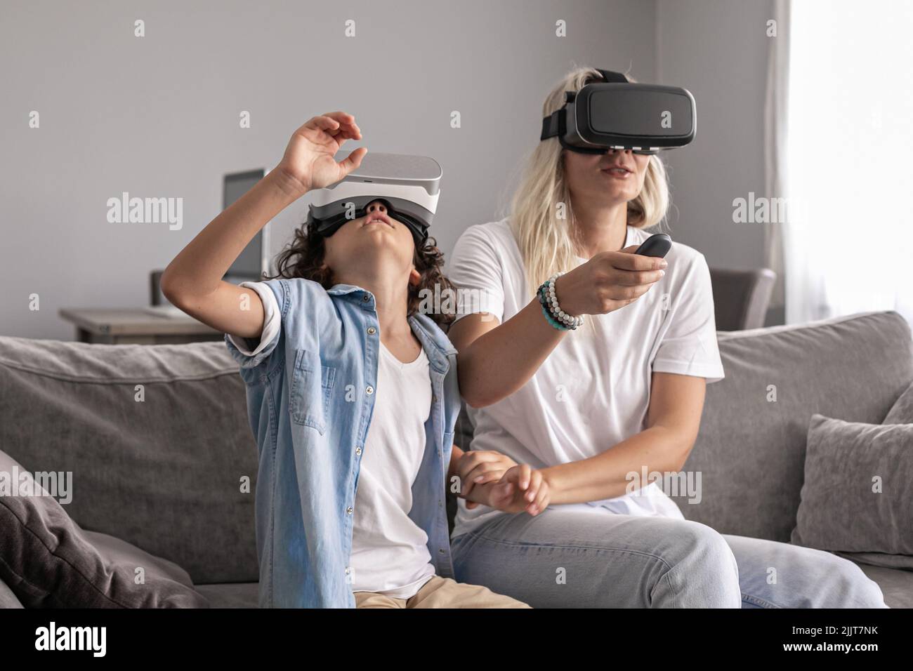 Mother and child wearing virtual reality headset vr glasses in living ...