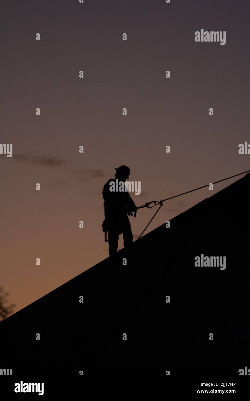 A closeup of a man on the roof with a sunset sky background Stock Photo ...