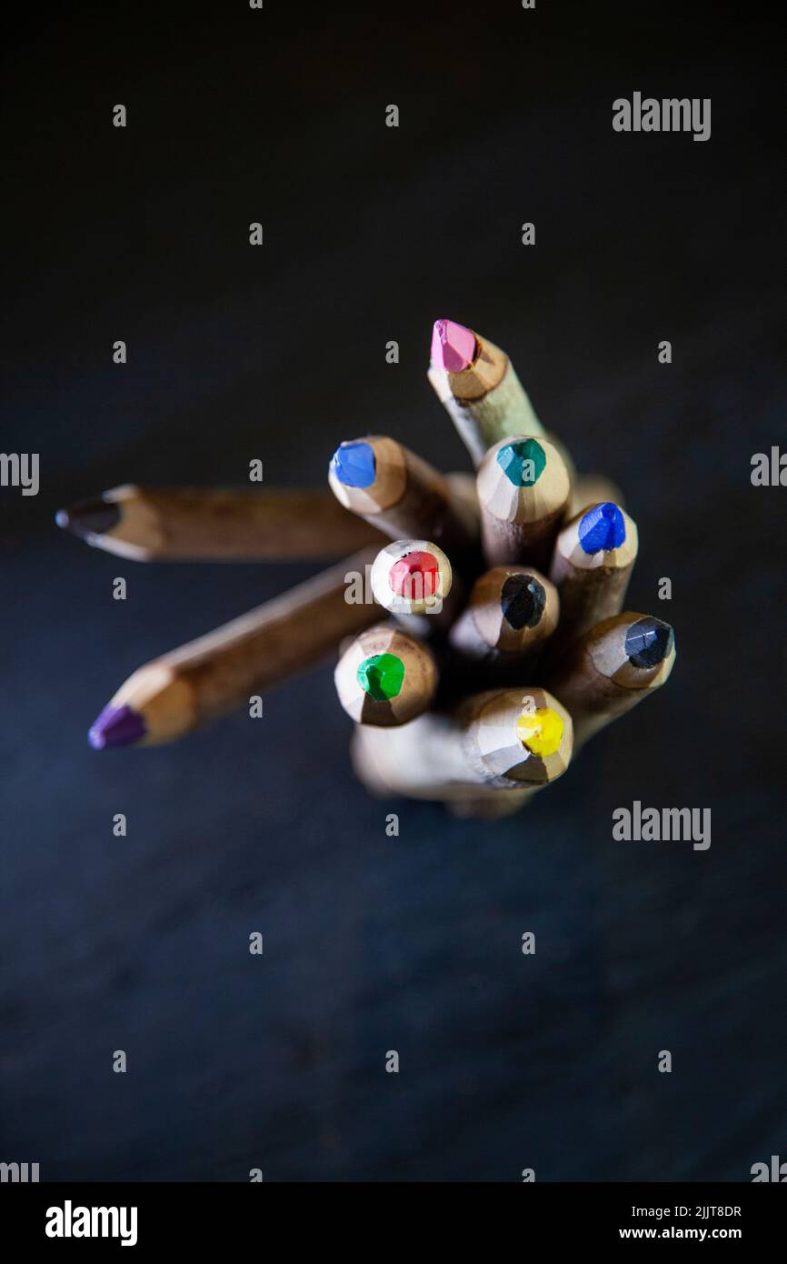 A group of standing wooden color pencils on a dark surface Stock Photo ...