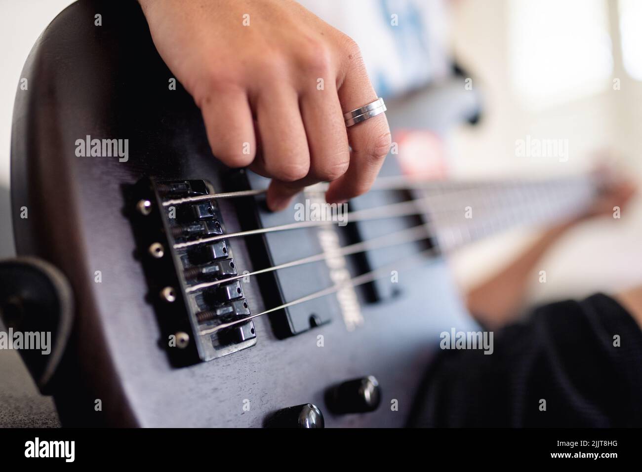 A man practicing his bass guitar with a ring on his finger Stock Photo ...