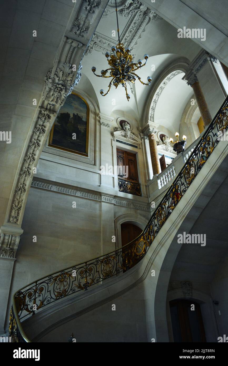 A vertical shot of an interior of fancy staircase in a museum in Paris ...