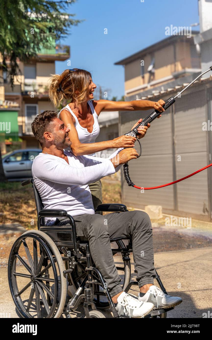 happy middle aged couple with disabled man sitting on wheelchair ...