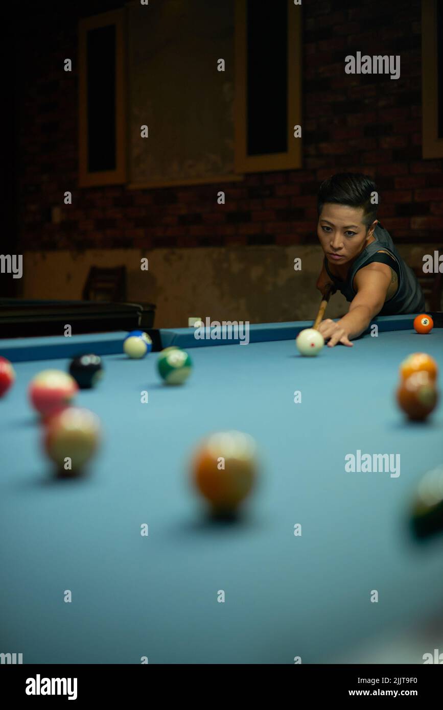 Concentrated Asian woman enjoying playing snooker in the bar Stock ...