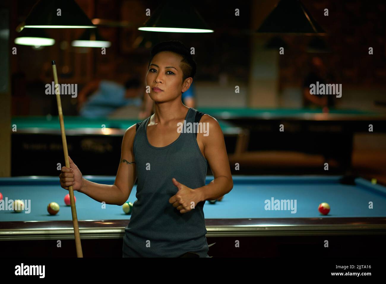 Vietnamese female billiard player with cue showing thumbs-up Stock ...