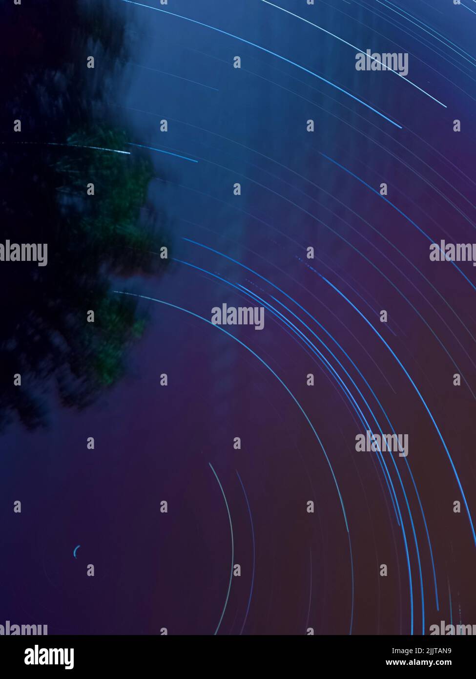 A vertical long exposure shot of star trails in a night sky Stock Photo ...